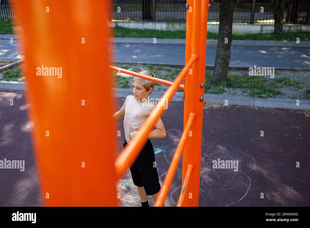Athletic teenager getting ready to perform pull-ups on the bar. Street ...