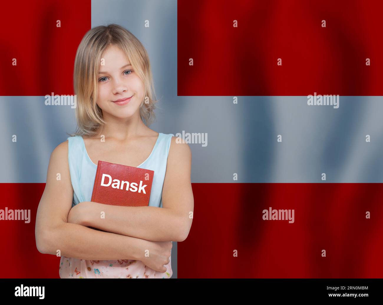 Positive teen girl with book with inscription Danish in Danish language ...