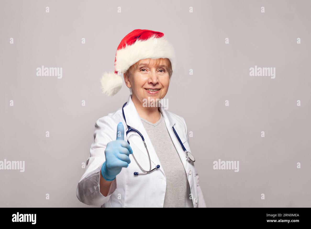 Portrait of Christmas doctor or nurse Santa with thumb up on white ...