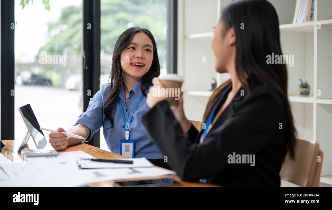 Two coworkers sitting together table hi-res stock photography and ...