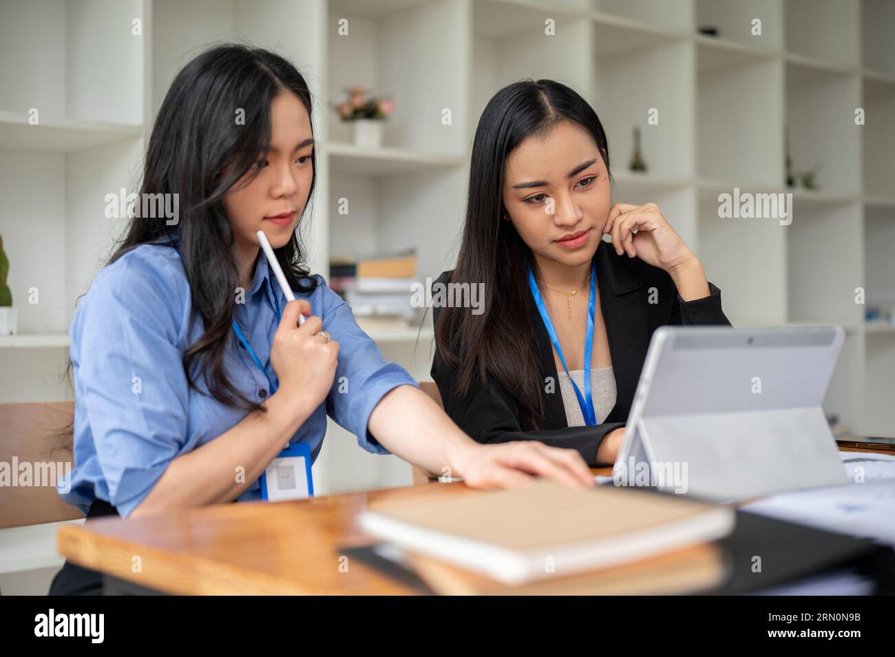 Two professional Asian female accountants or businesswomen are focusing ...