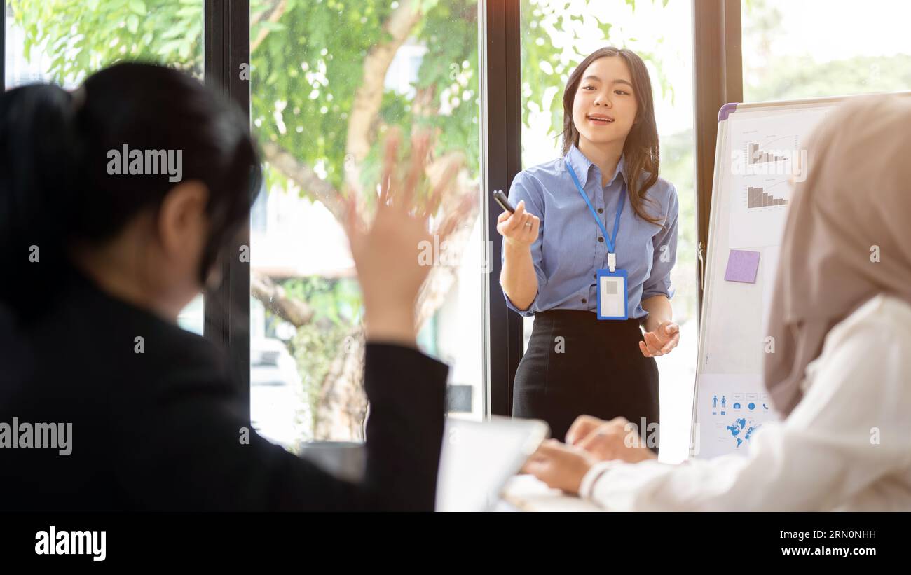 A confident and professional Asian businesswoman let everyone in the ...