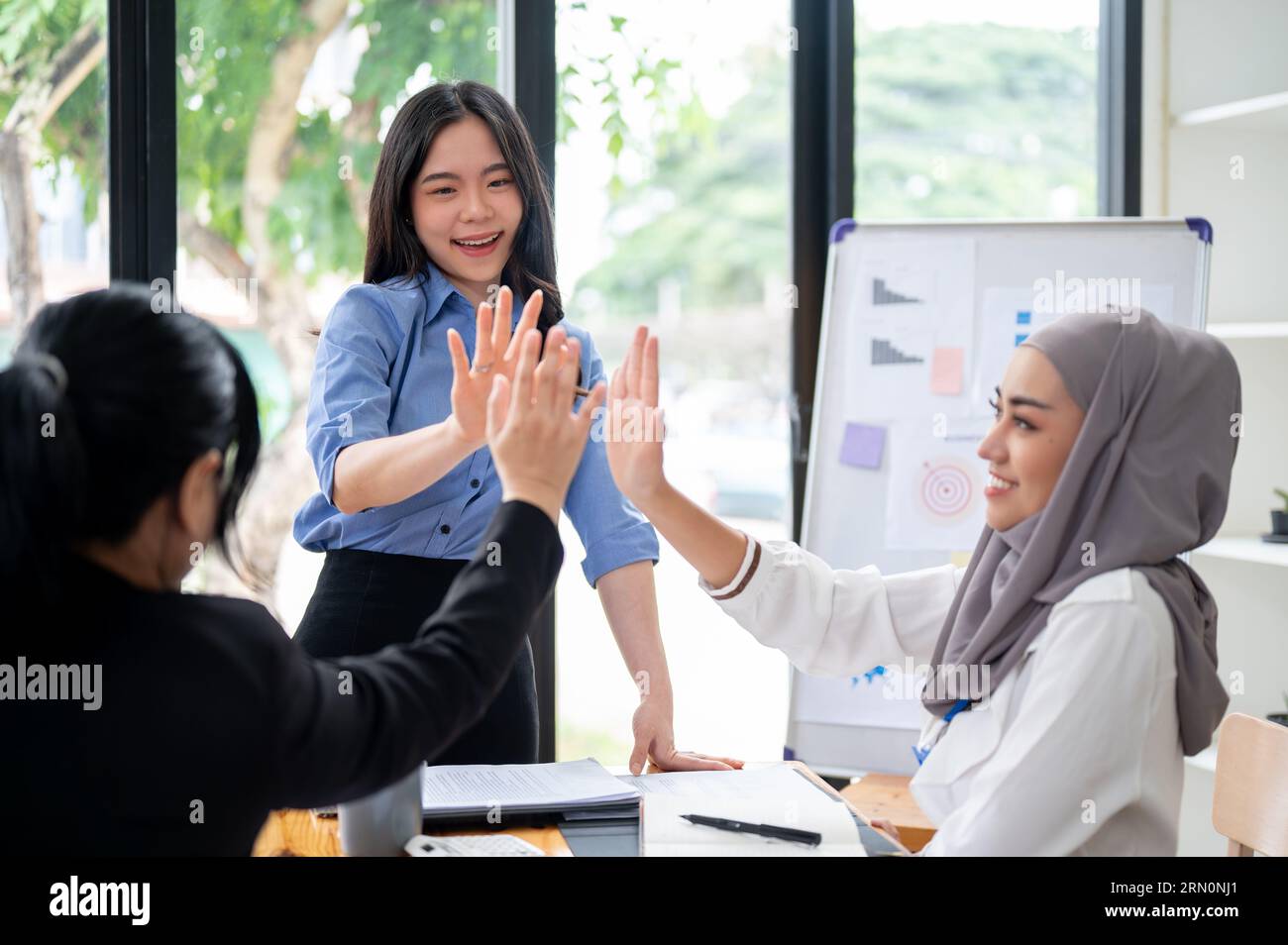 Diverse businesspeople are putting their hand together after the ...