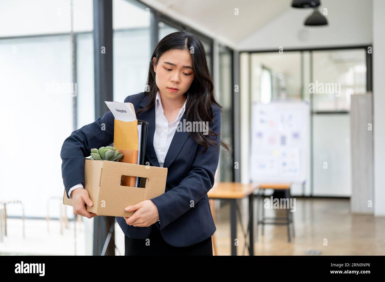 Sad and upset young Asian female office worker walks out of the office ...