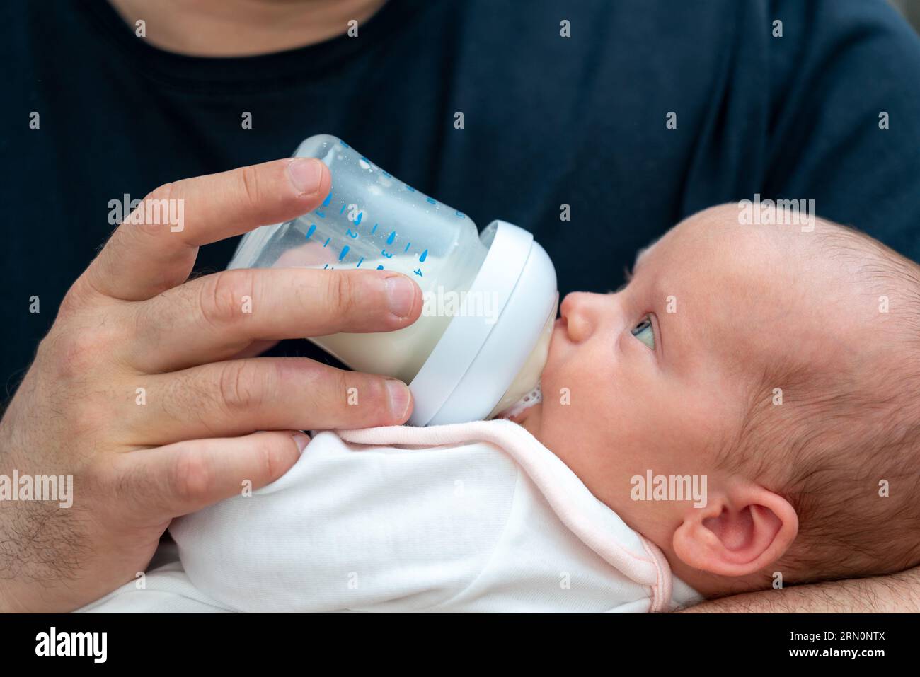 Man expressing his deep love as a father, holding newborn and feeding ...