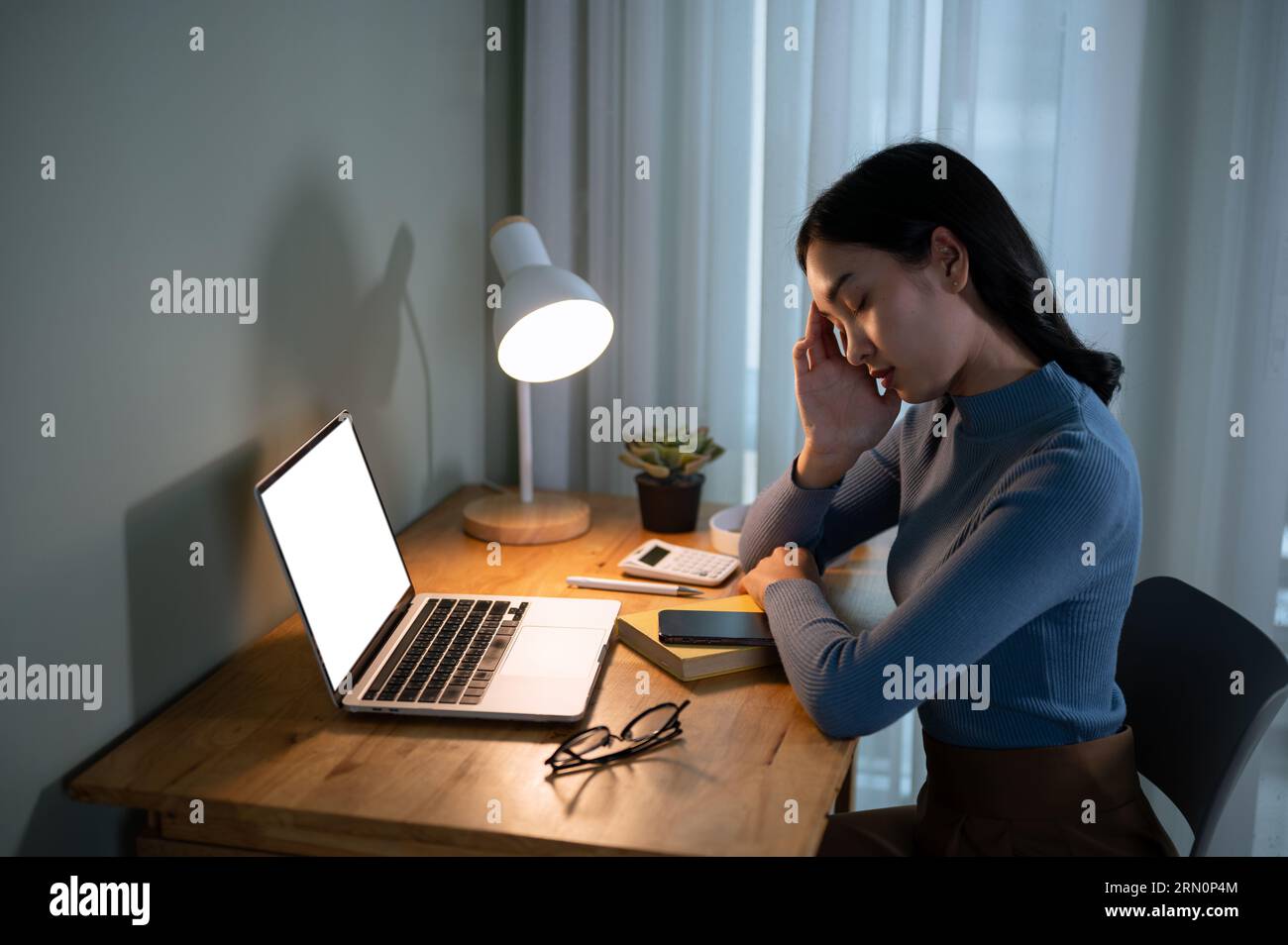 A tired and sleepy young Asian female college student is falling asleep ...