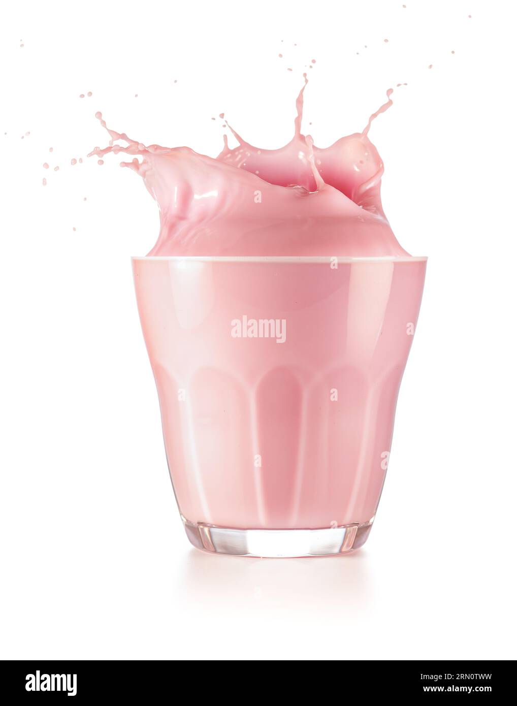 Pink milkshake splashing out of drinking glass isolated on white ...