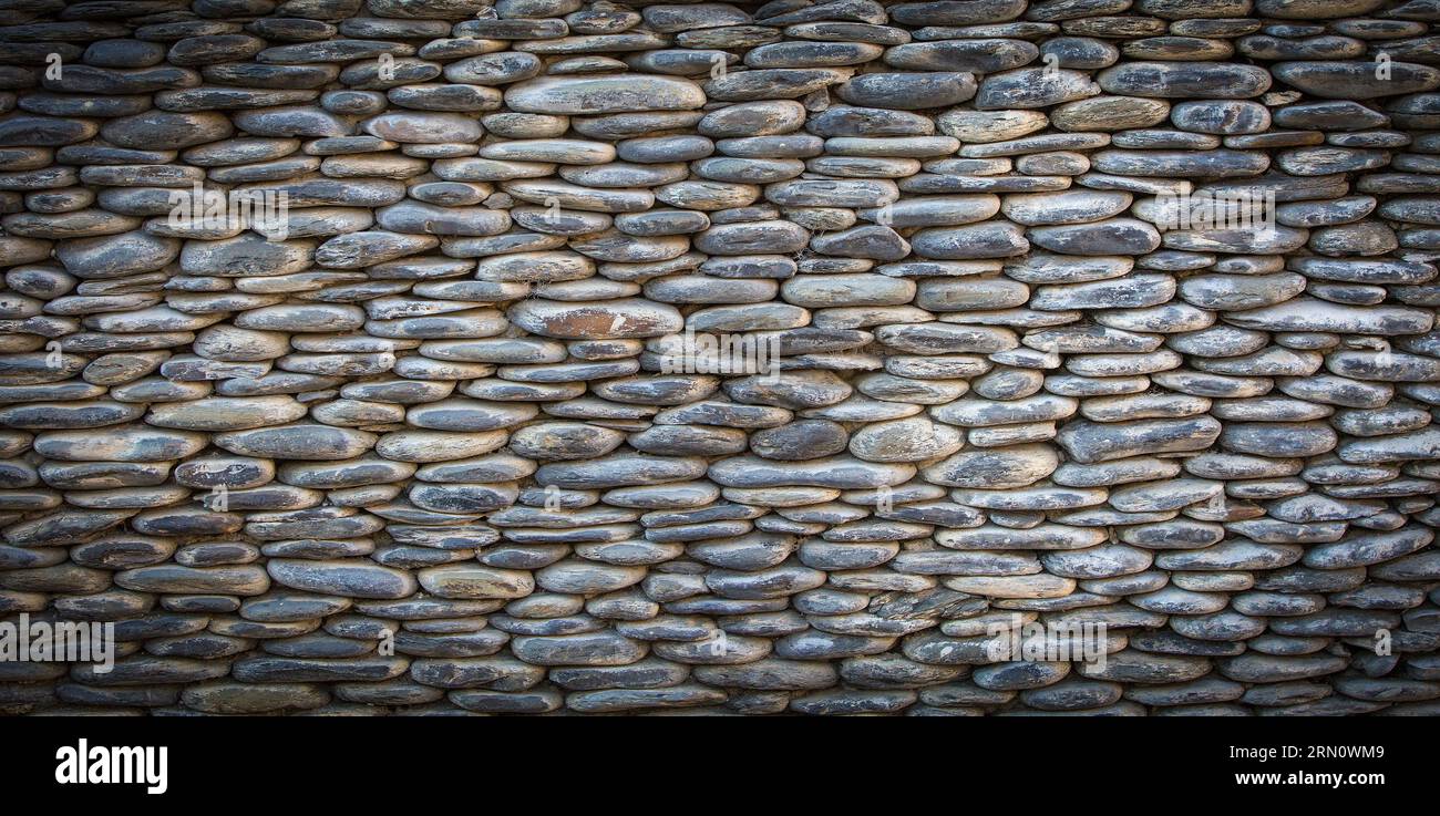 The grey river pebbles round stone wall background Stock Photo - Alamy