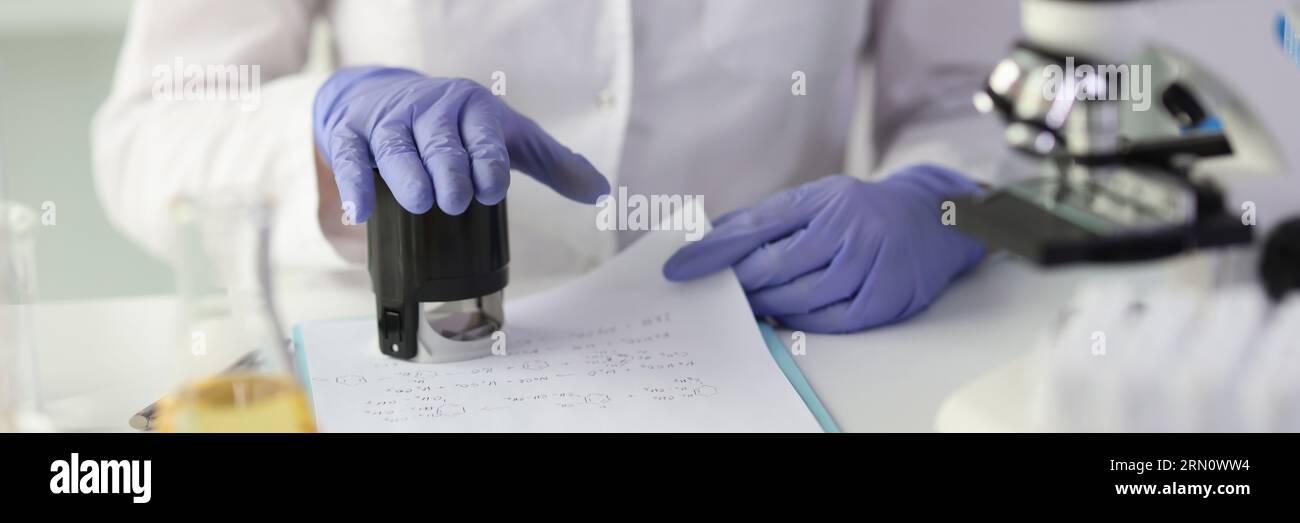 Researcher putting stamp on documents with research results Stock Photo ...