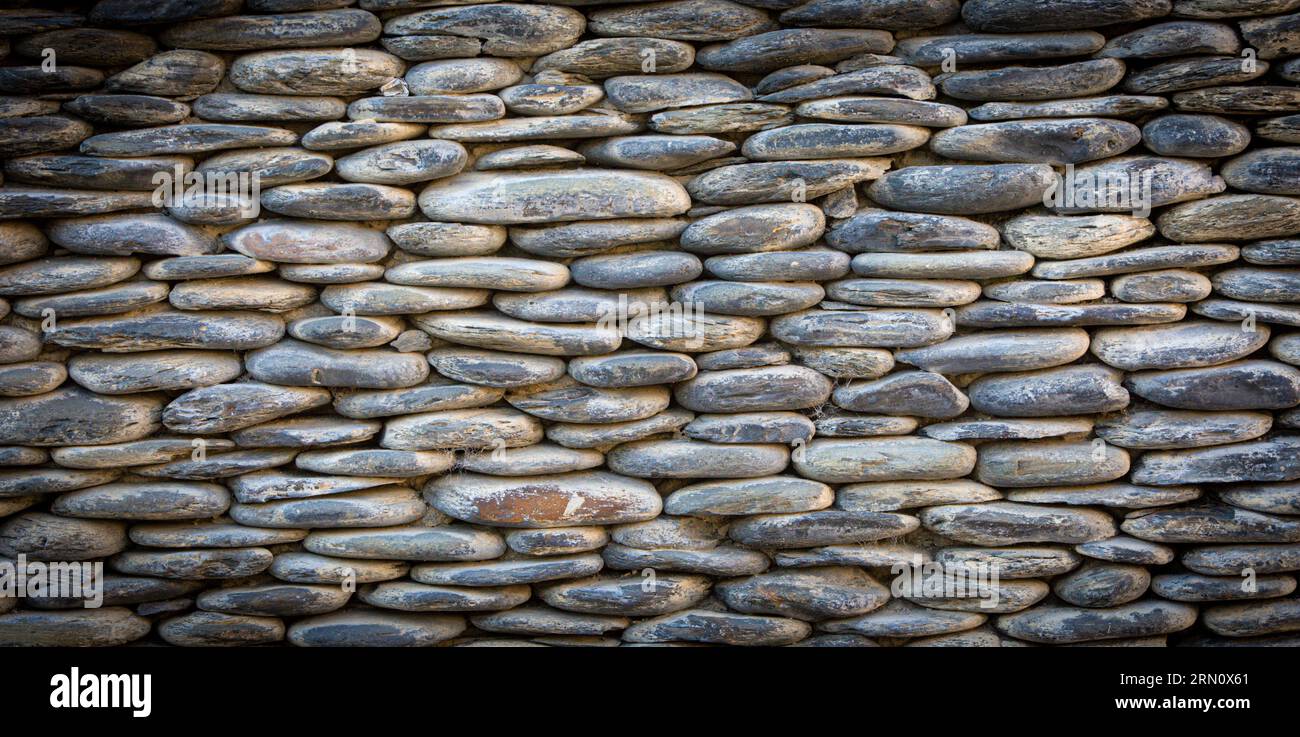 The grey river pebbles round stone wall background Stock Photo - Alamy