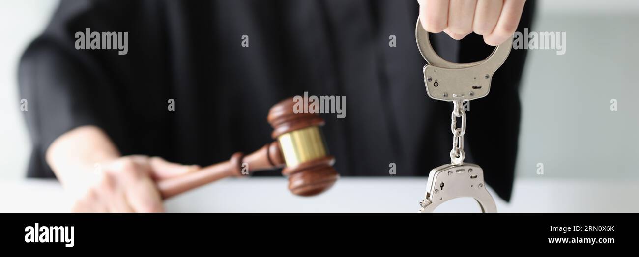 Judge with wooden gavel and holding handcuffs Stock Photo - Alamy