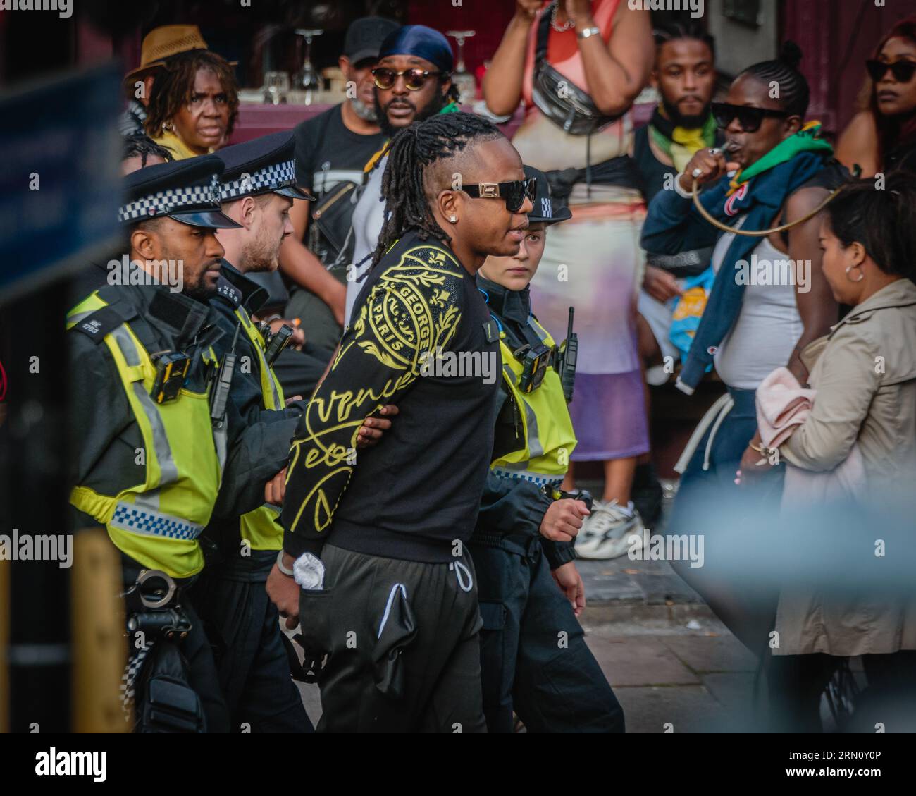 A man is lead away in handcuffs by the police at the Notting Hill ...
