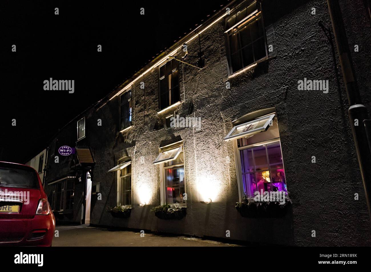The Anchor Inn pub illuminated at night outside in the village Stock ...