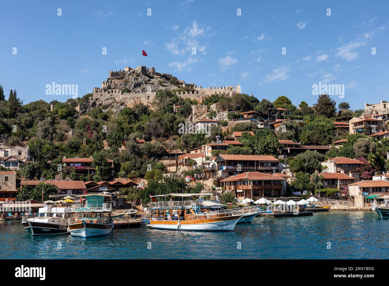 Simena village and castle as seen from an arriving tourist tour boat ...