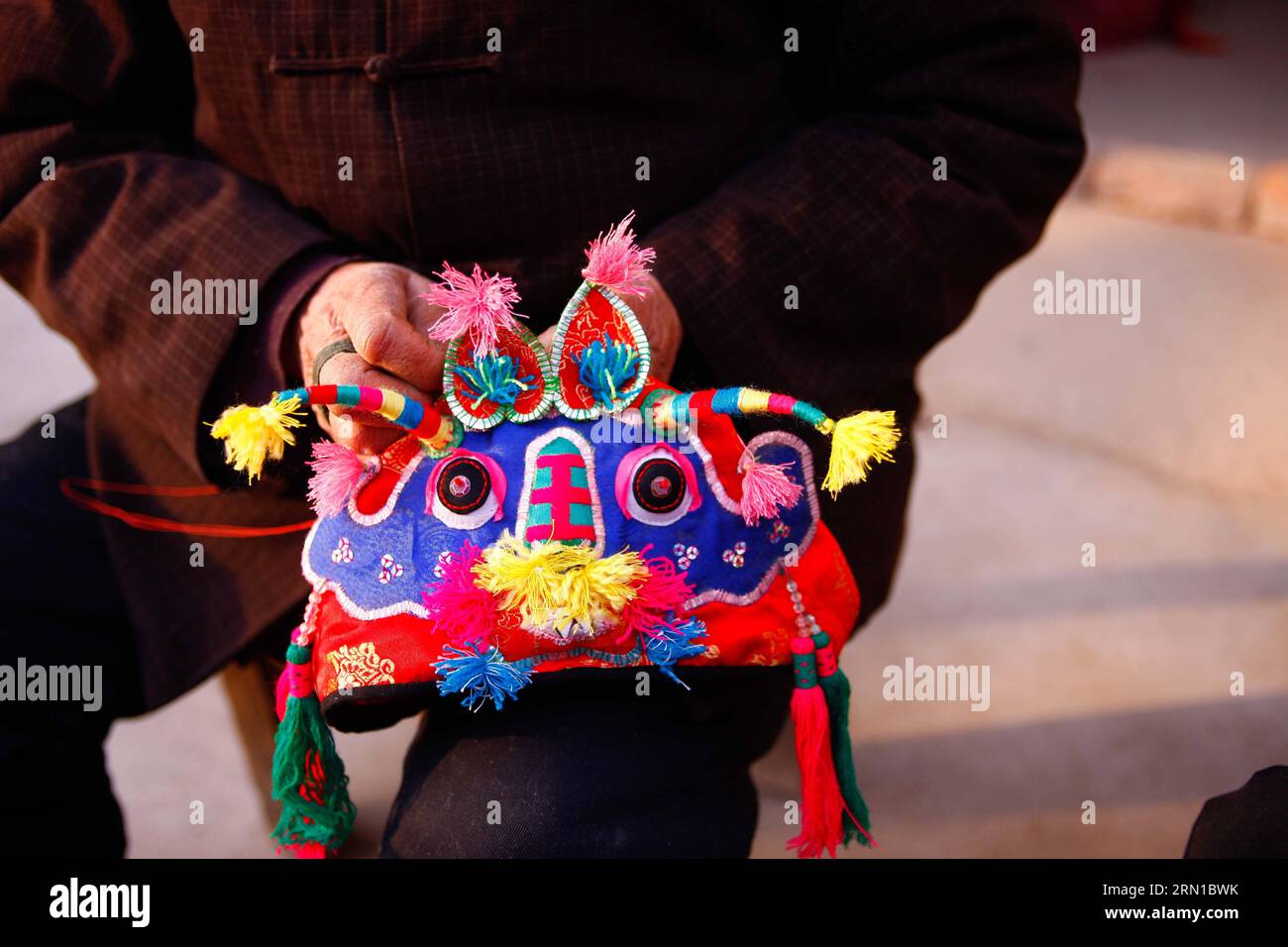 Sun Jinglan makes a tiger hat at home in Liwa Village, Duji District of ...