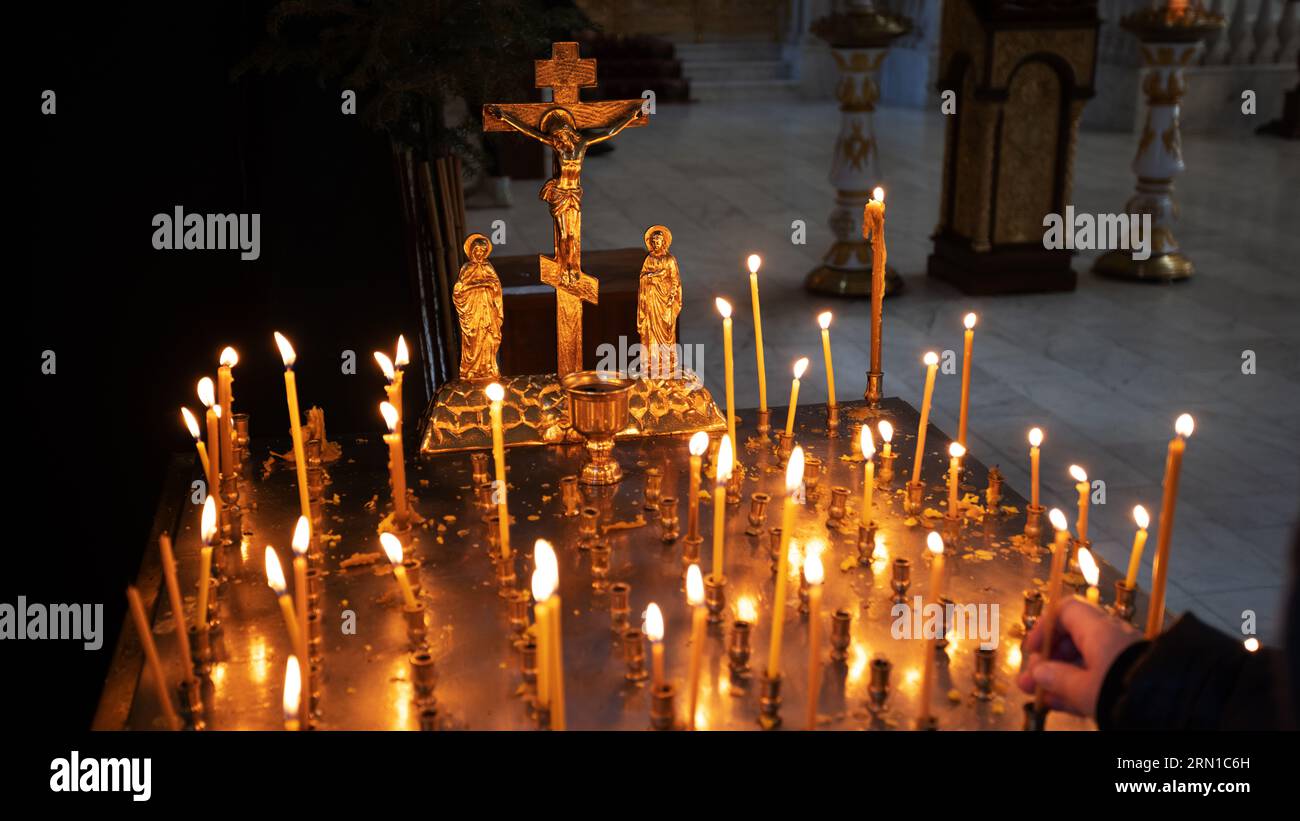 Concept of Christian religion. Cross with crucifix in focus, lit wax ...