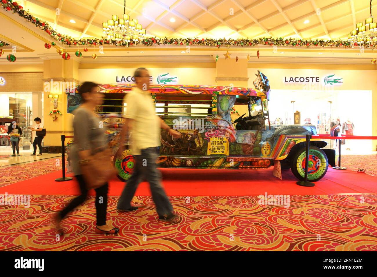 People walk past a colorful jeepney during the Jeepney Design Challenge ...