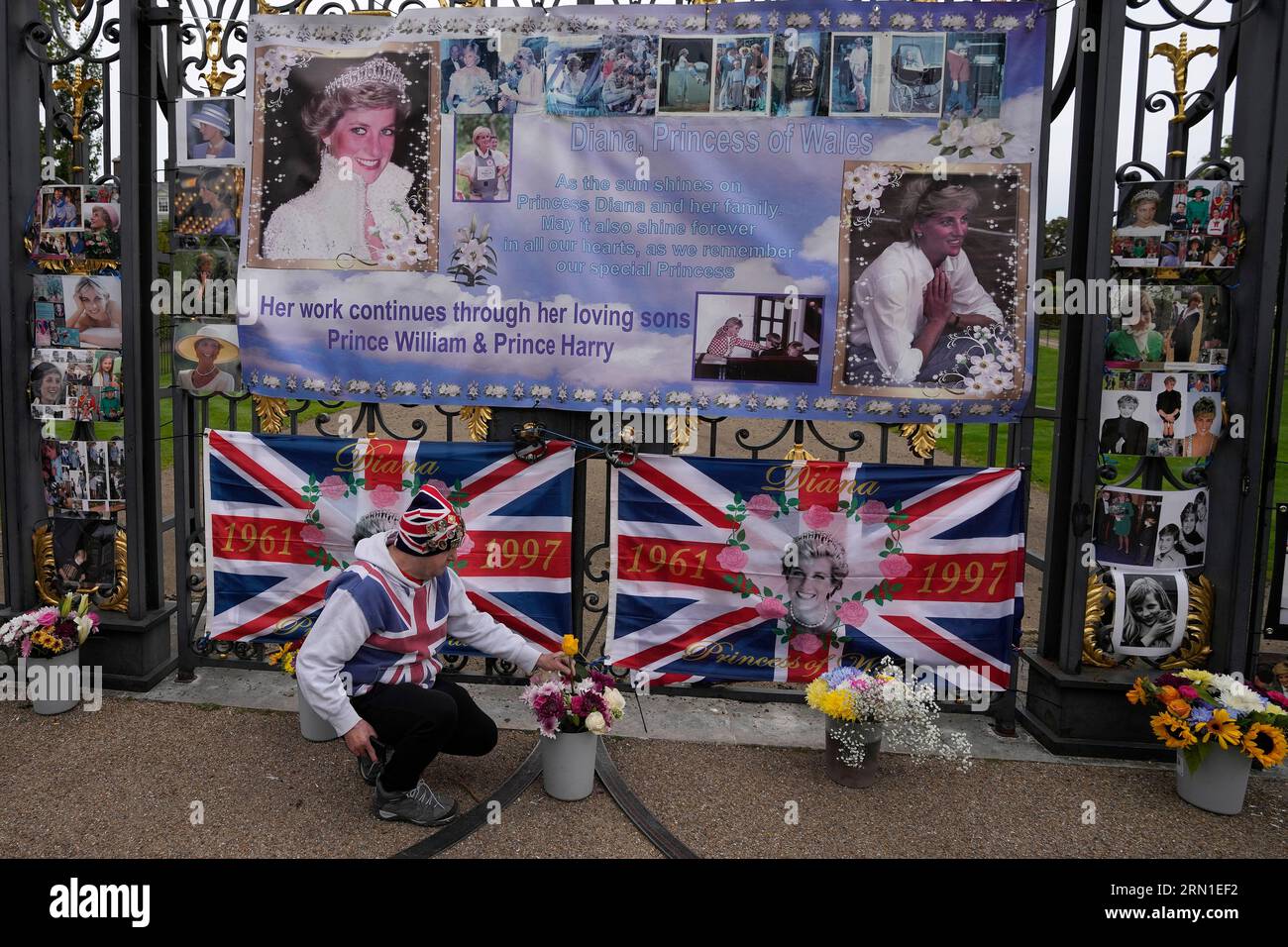 Royal fan John Loughrey puts down flowers in front of pictures of ...