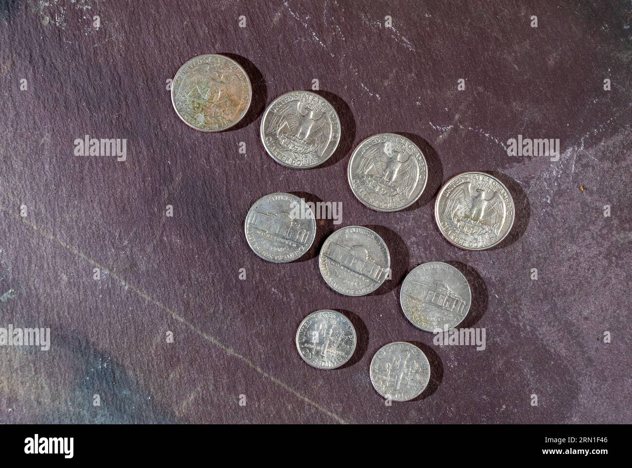 Reverse of nine American coins arranged in a pattern on a grey slate ...