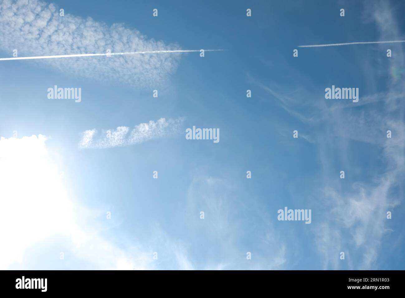 Cirrus clouds and long airplane trail row. Aero plane contrail in blue ...