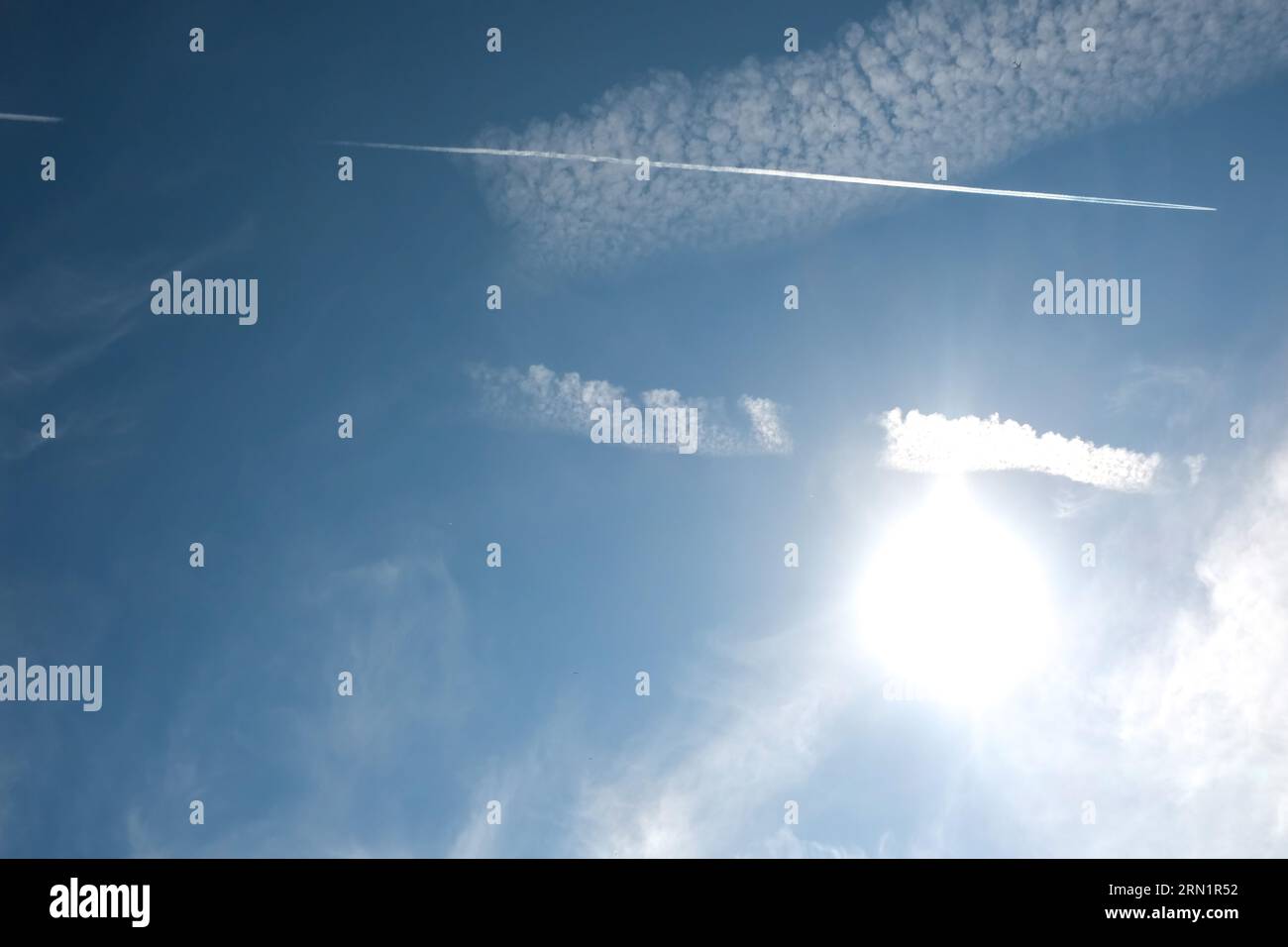 Cirrus clouds and long airplane trail row. Aero plane contrail in blue ...