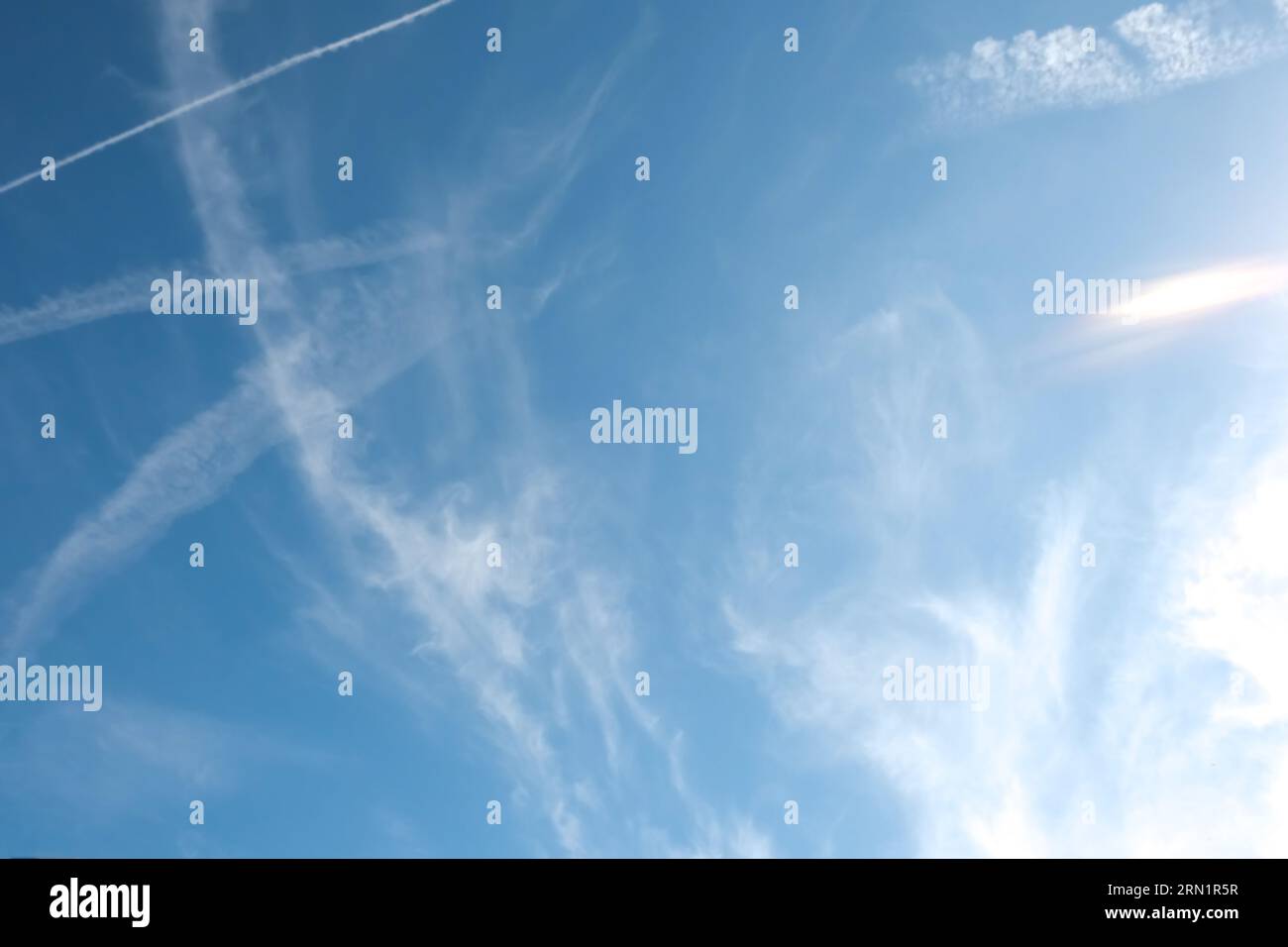 Cirrus clouds and long airplane trail row. Aero plane contrail in blue ...
