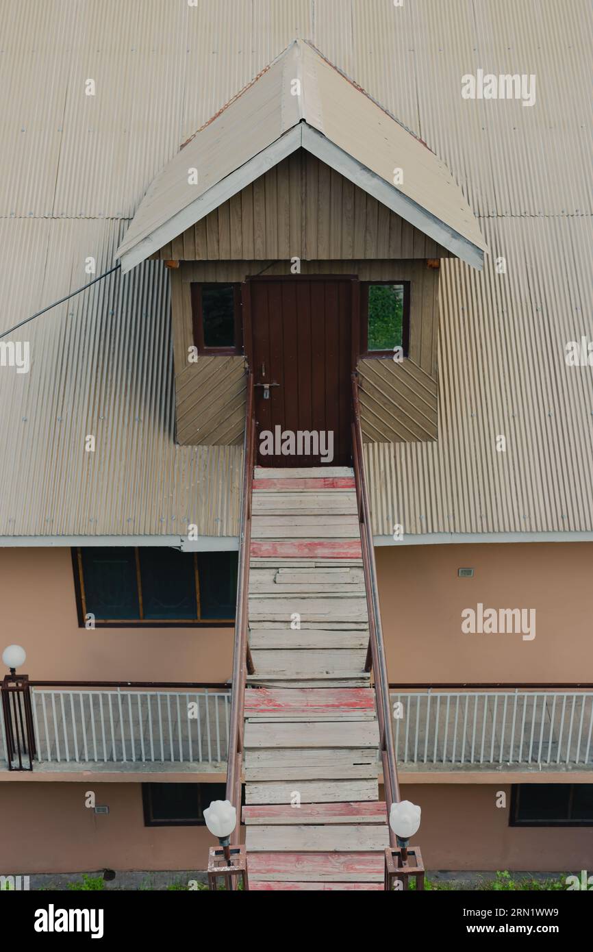 An aerial view of a wooden hut with a metallic roof and steps leading ...