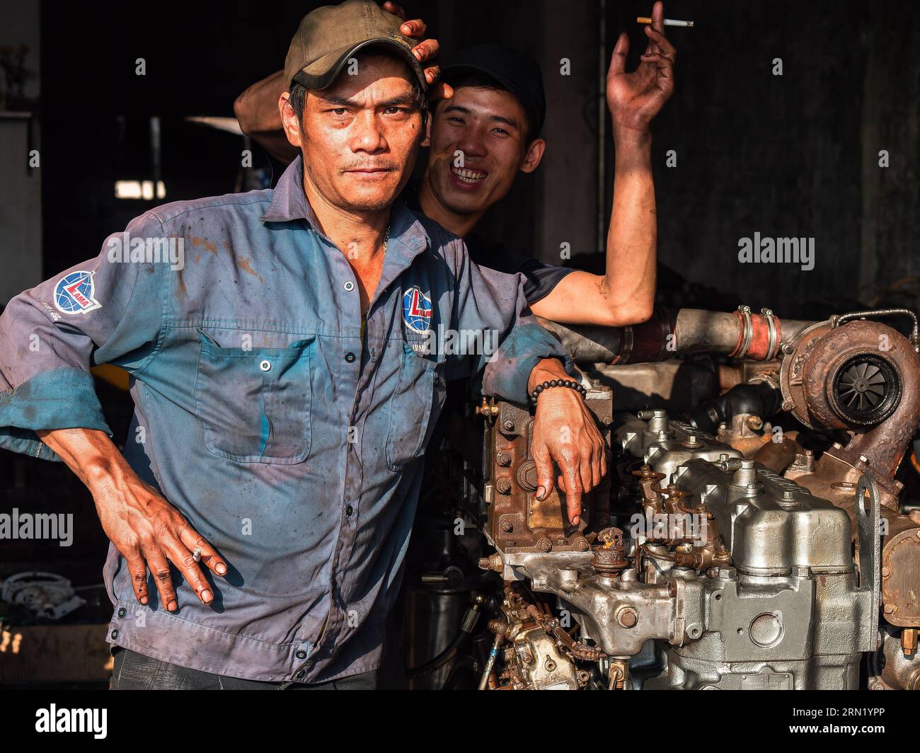 Mechanics repairing diesel engines for fishing boats in Quang Nham, a ...