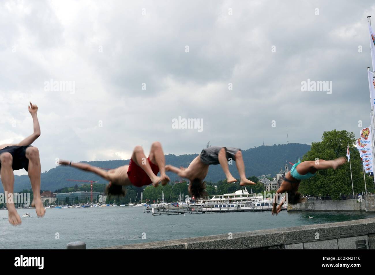 Three young men and one woman are jumping backwards to Lake Zurich ...