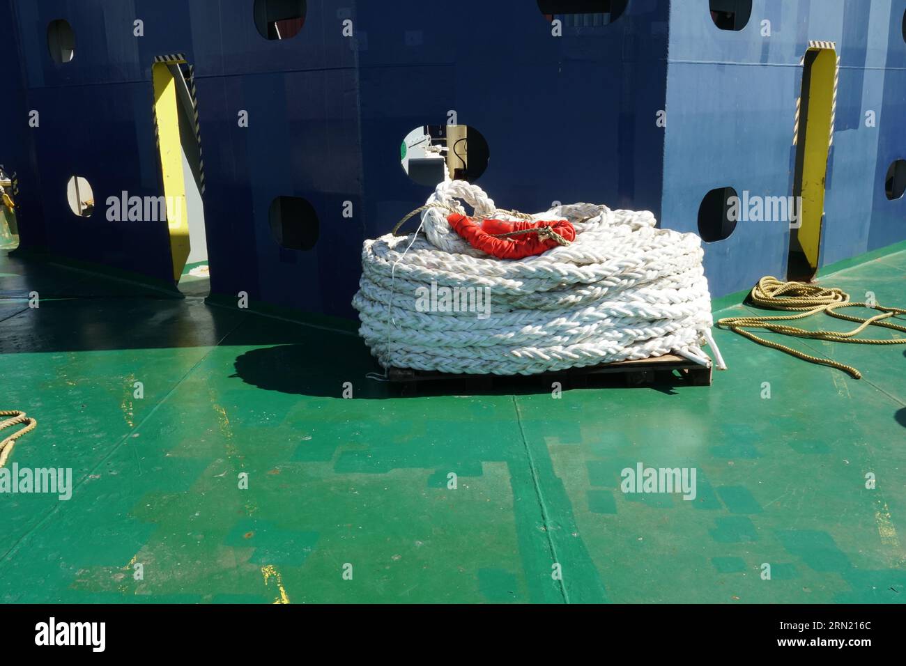 White fibre mooring rope or line rolled up in forward mooring station ...