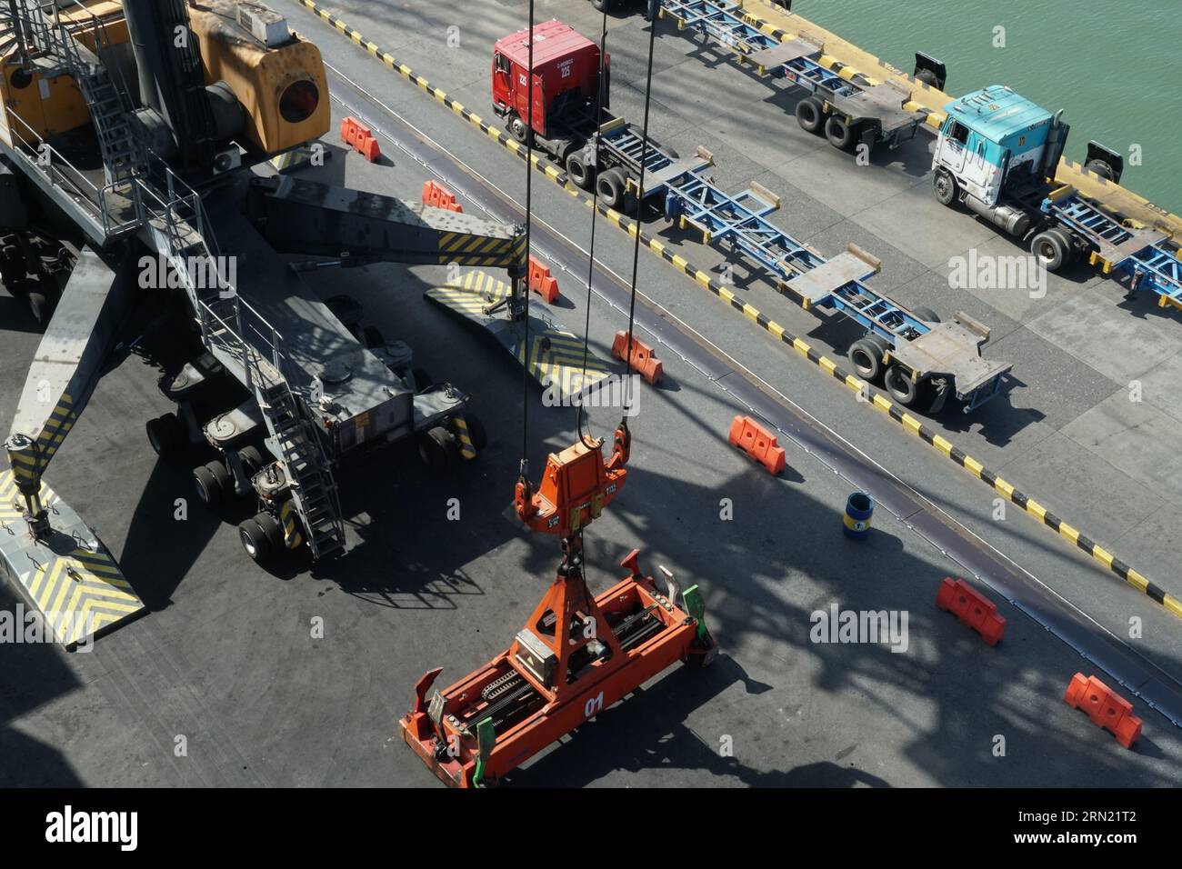 Mobile cranes with orange spreader operated by stevedores in Guatemala ...