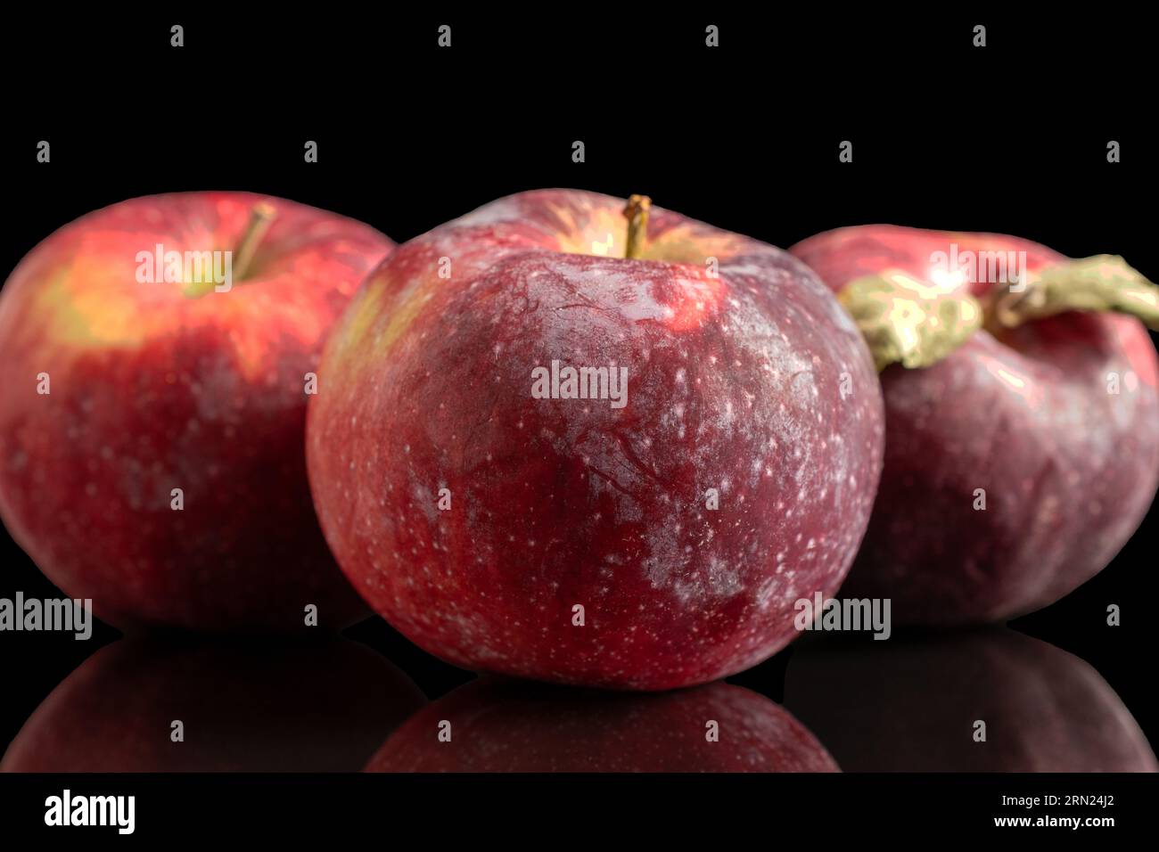 Three juicy dark red apples, macro, isolated on black background Stock ...