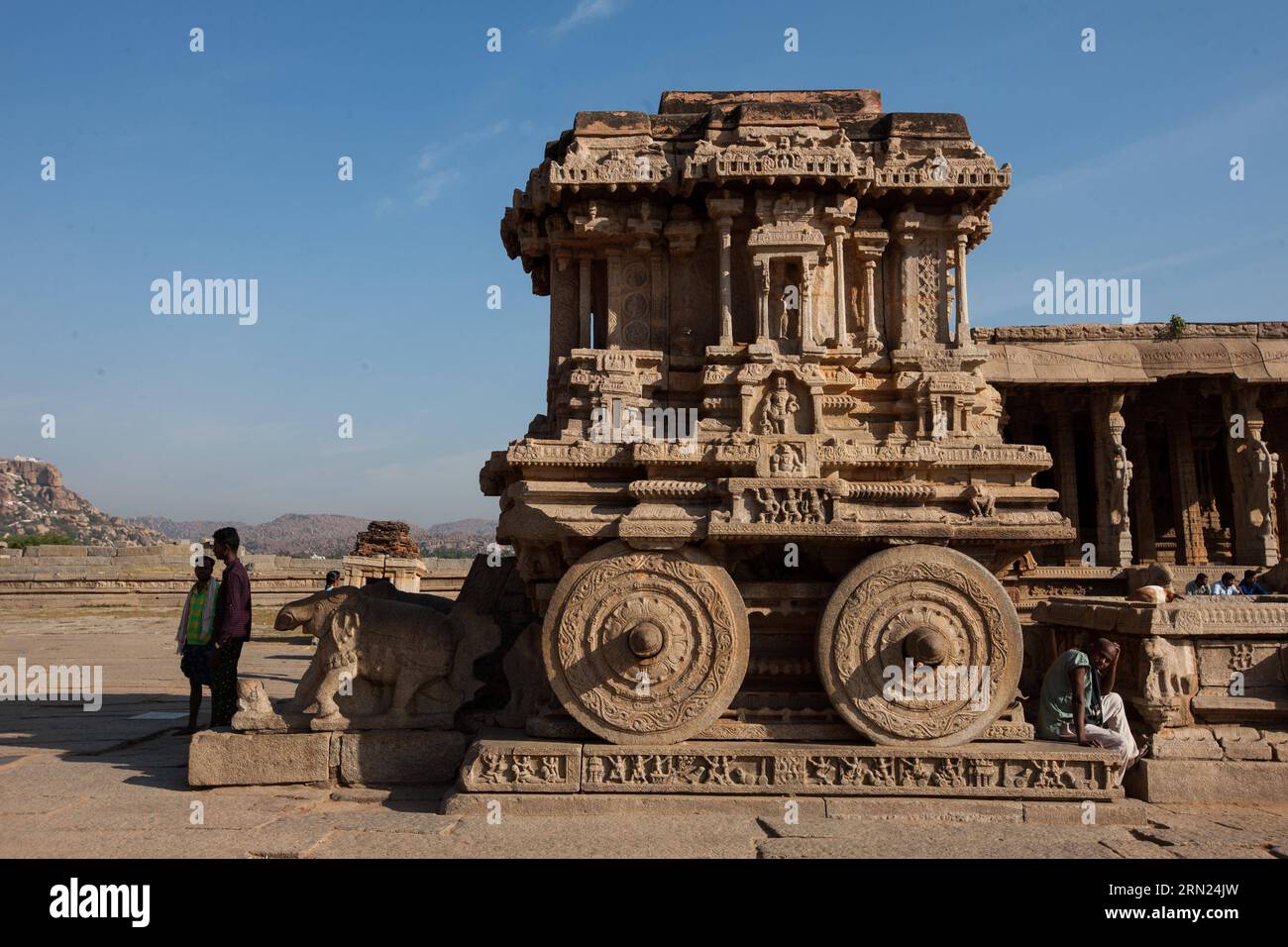 Tourists visit the stone chariot in Vittala Temple of Hampi in Bellary ...