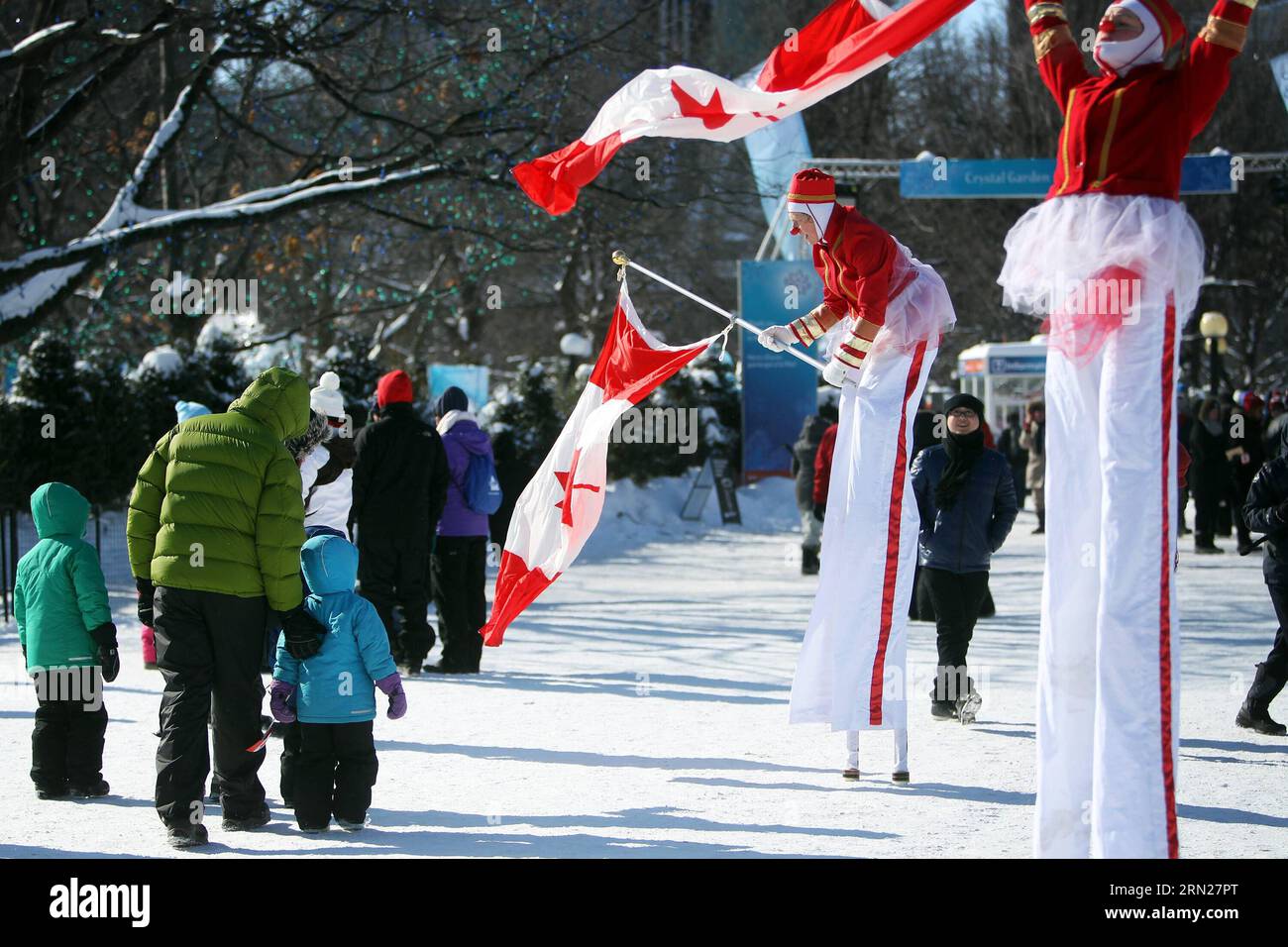 Clowns on stilts wave Canadian flags at a ceremony marking the 50th ...