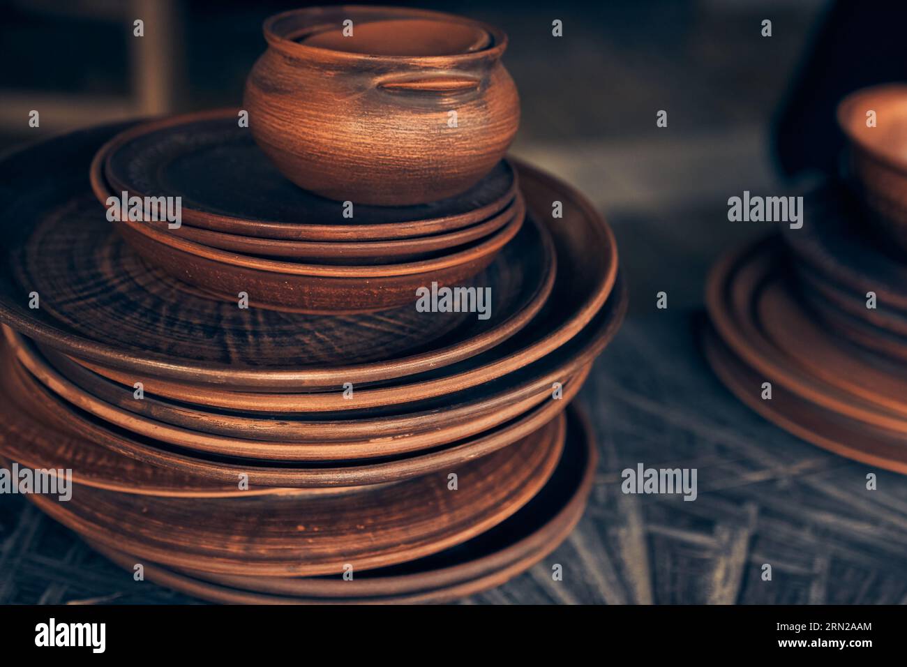 A stack of clay plates of different sizes on a dark background. Level ...