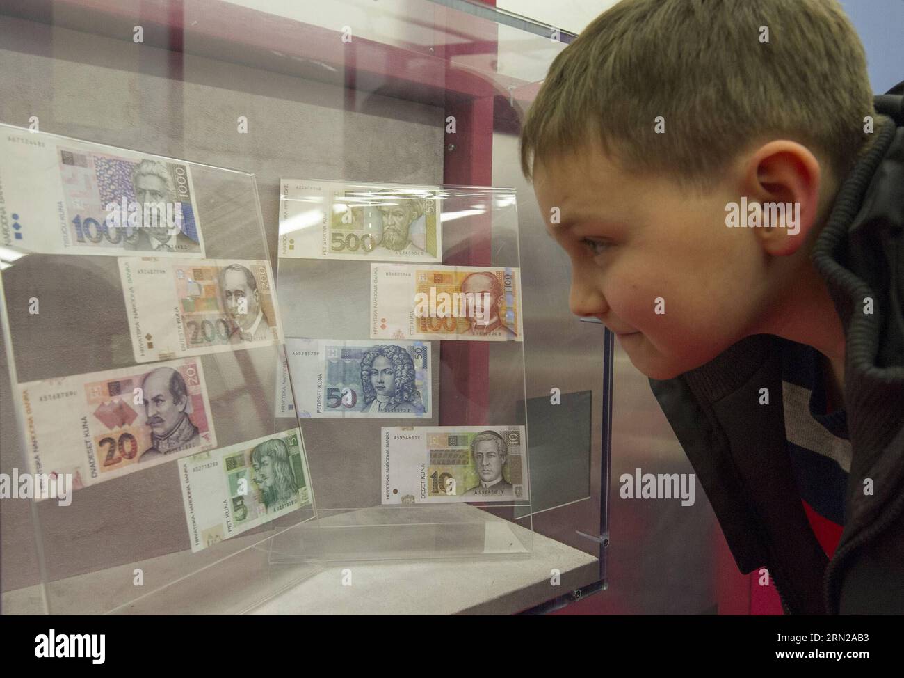 A boy looks at Croatian Kuna banknotes during the Alphabet of Money ...