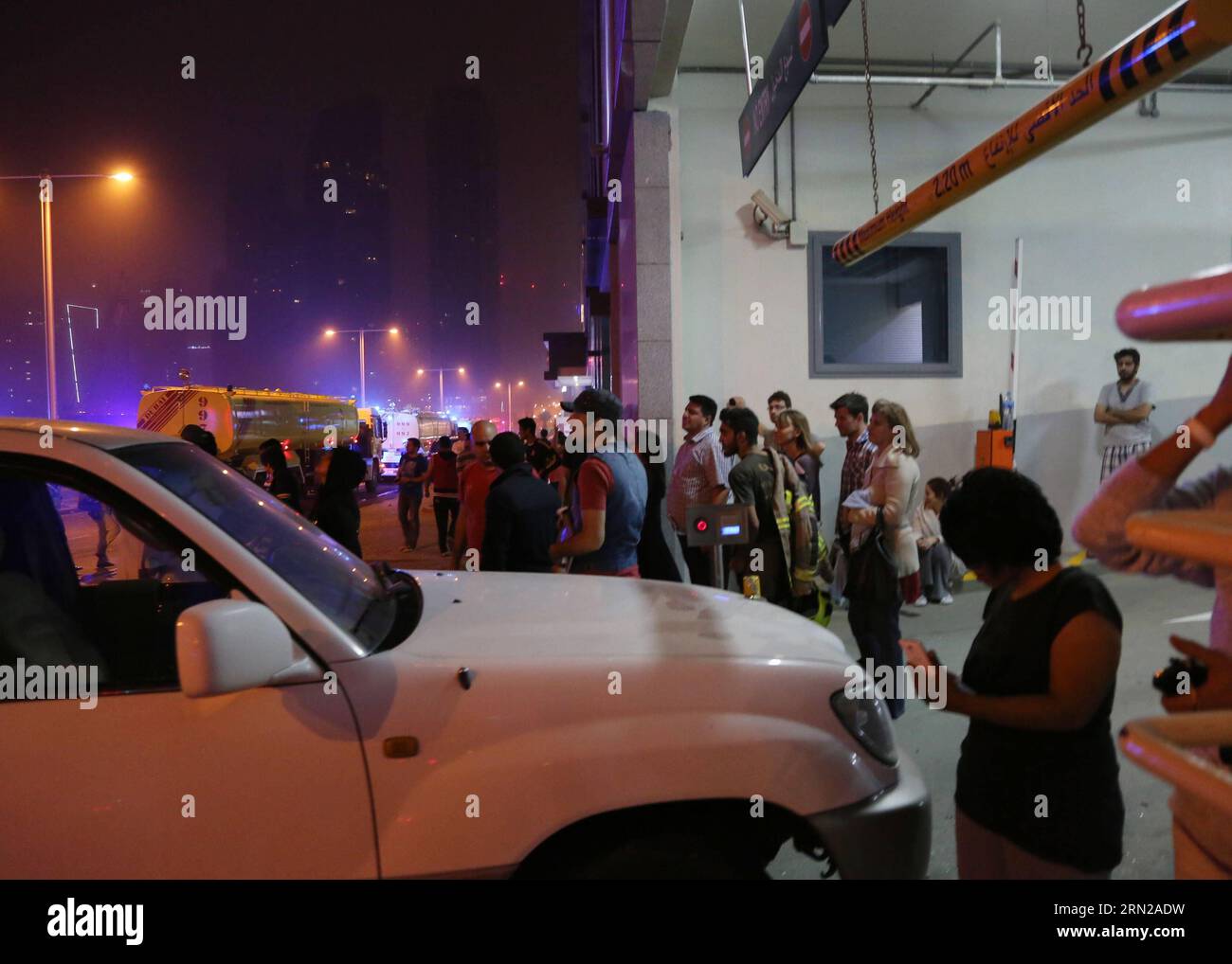 People gather in front of an entrance to the Marina Torch which caught ...