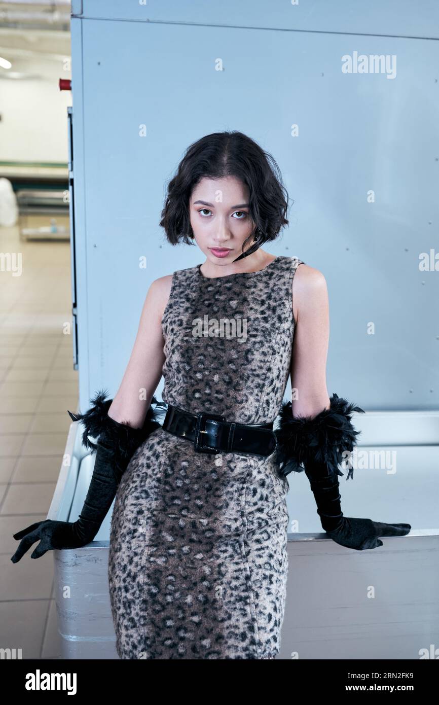 young asian woman in dress and gloves looking at camera while posing in public laundry Stock ...