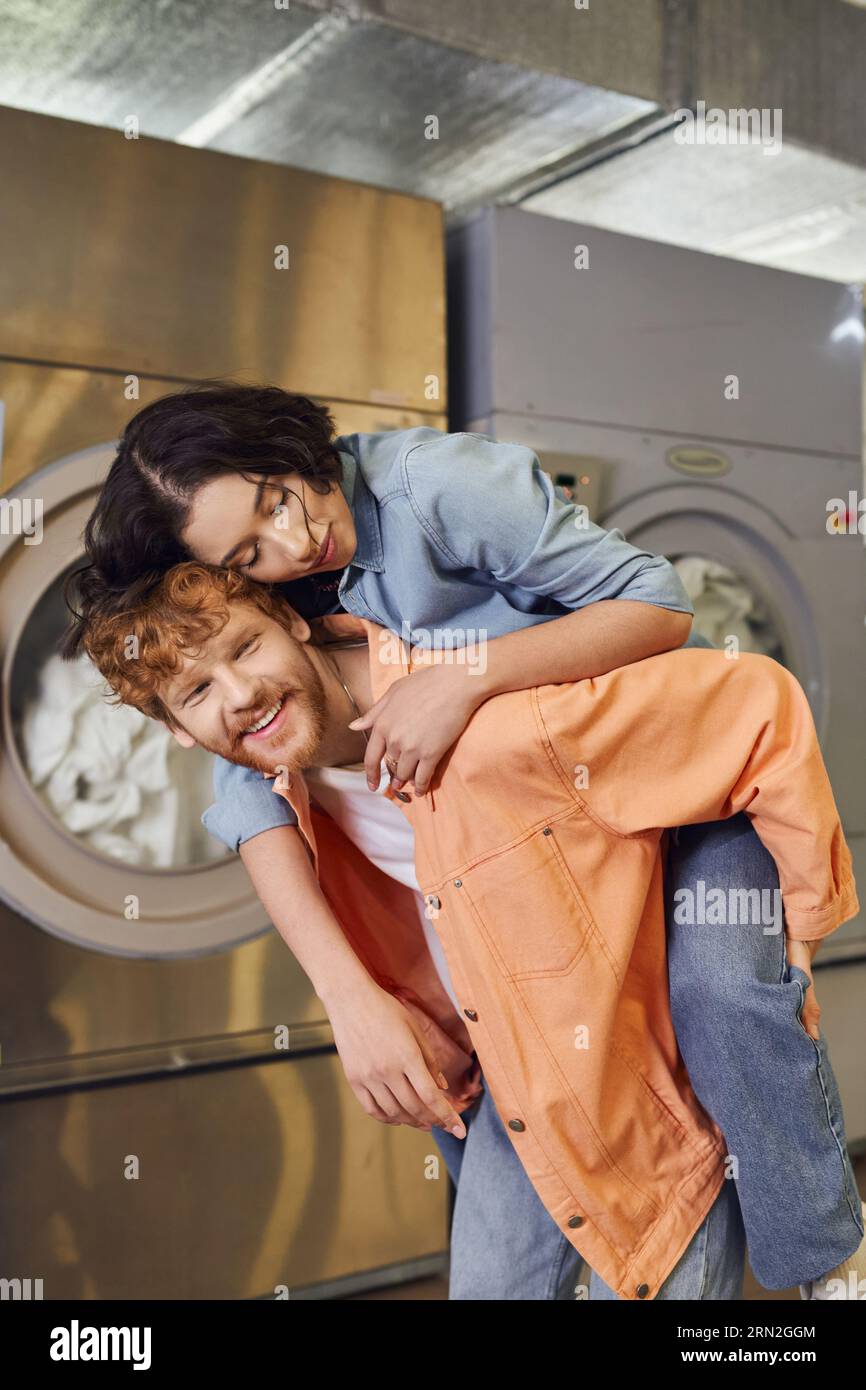 young asian woman piggybacking on smiling boyfriend in blurred public laundry Stock Photo - Alamy