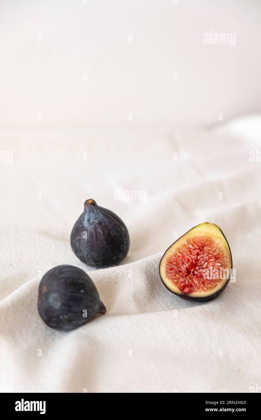Fresh ripe and sweet figs cut and whole on beige color table cloth ...
