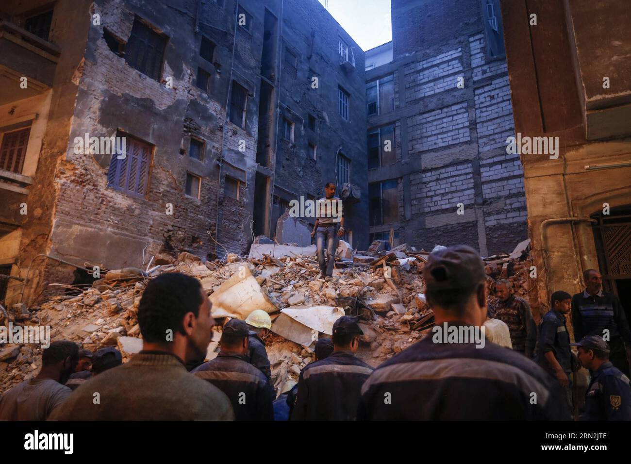 Rescuers work on the debris of a collapsed residential building in ...
