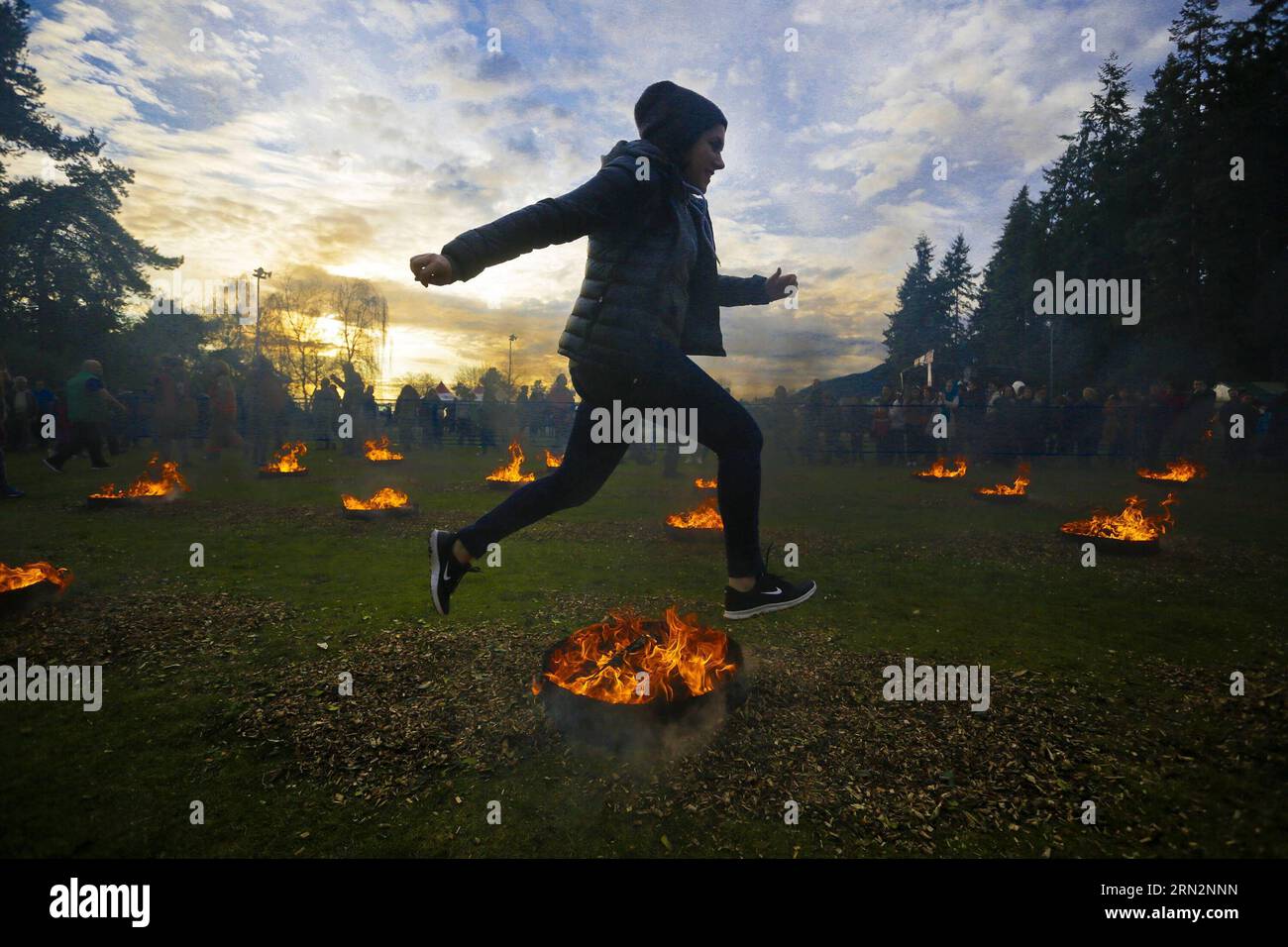 A resident leaps over a bonfire during Nowruz festival at Ambleside ...