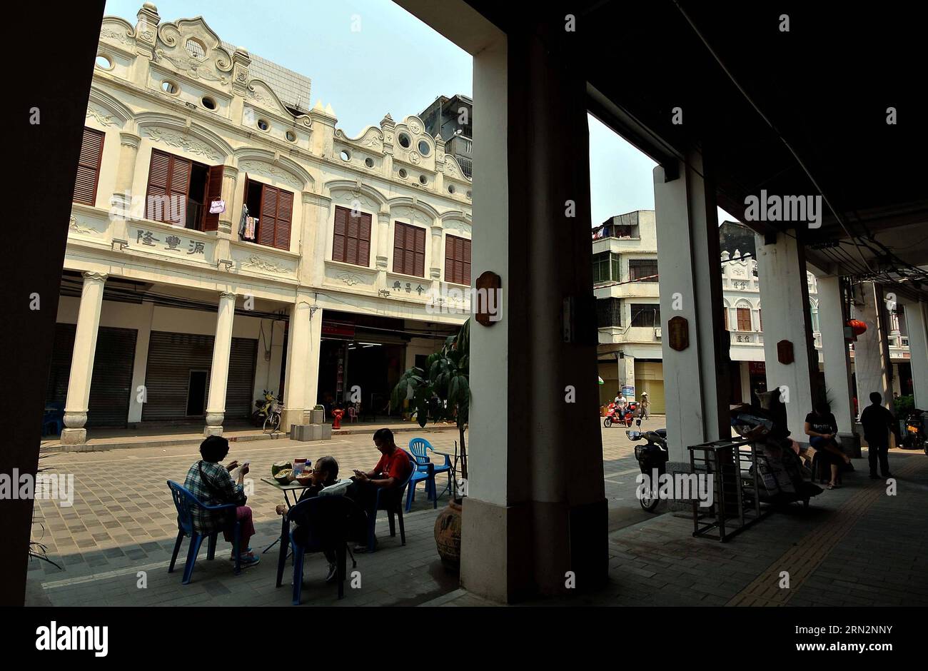 Residents take a leisure time on a corridor of a Qilou building in ...