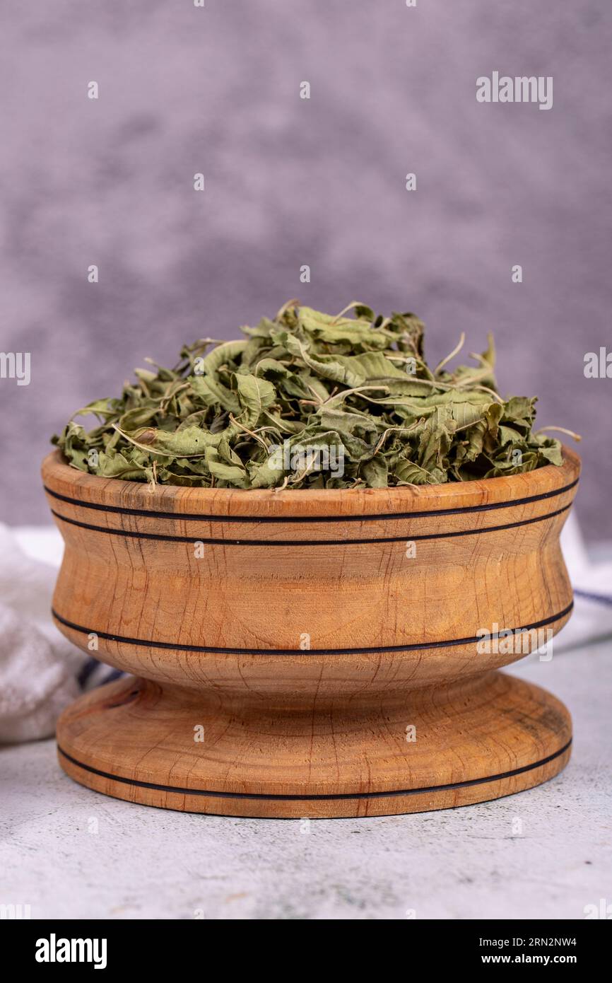 Dried balm tea. Sun-dried lemon balm tea leaves in wood bowl. herbal ...