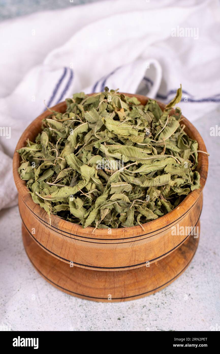 Dried balm tea. Sun-dried lemon balm tea leaves in wood bowl. herbal ...