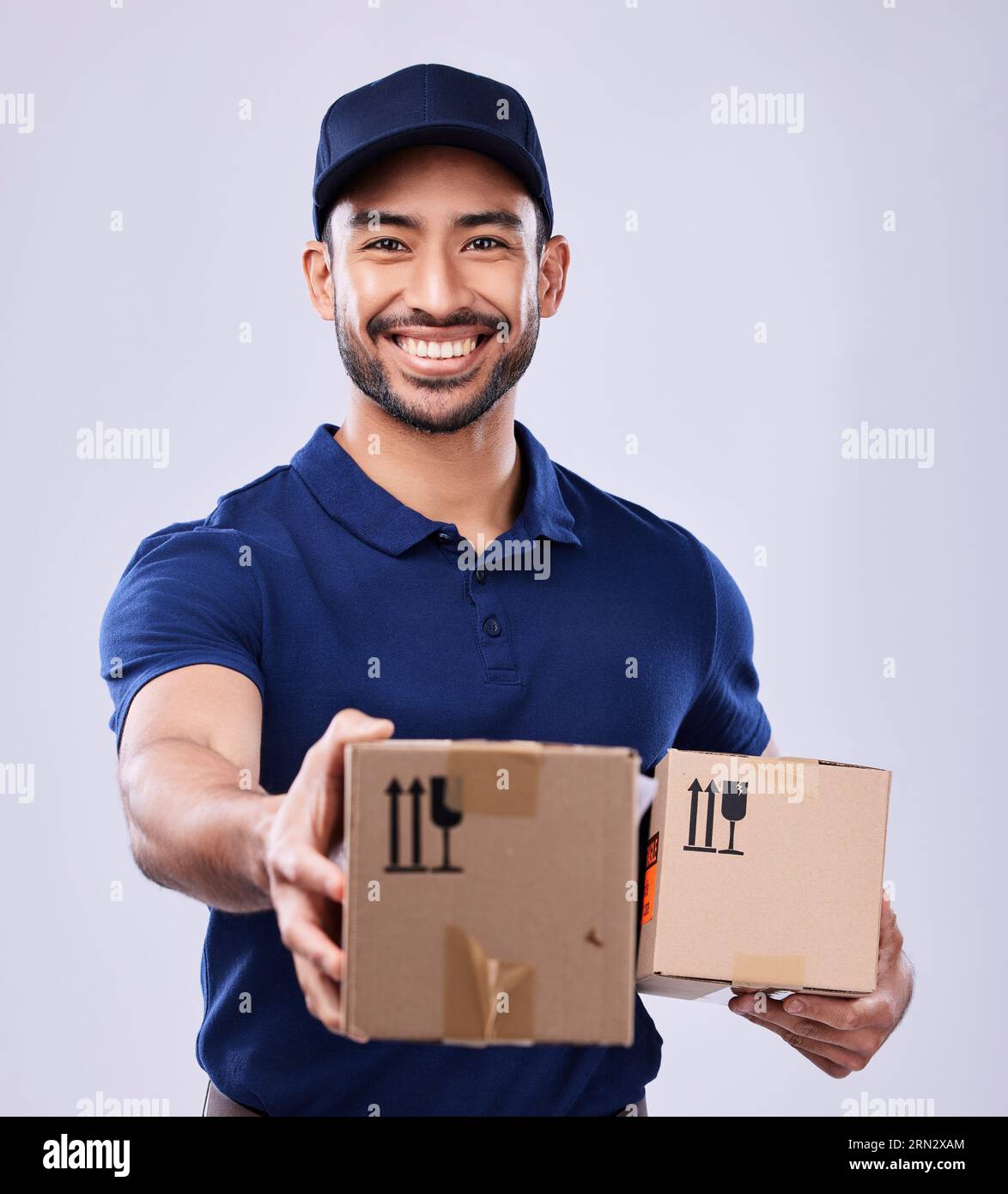 Smile, portrait and delivery man giving boxes in studio, safe transport for ecommerce supplier ...