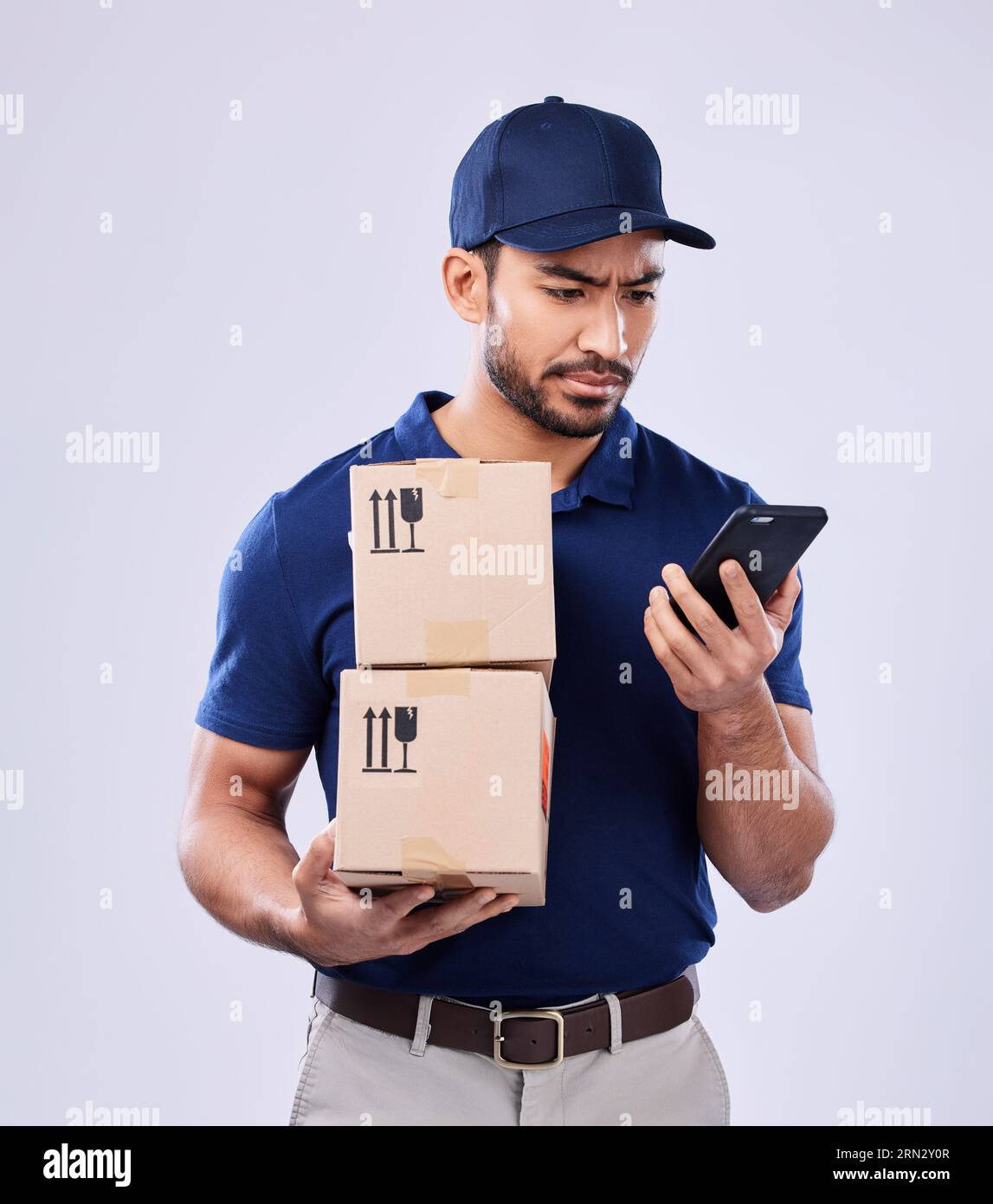 Phone, shipping box and confused delivery man reading online shopping ...