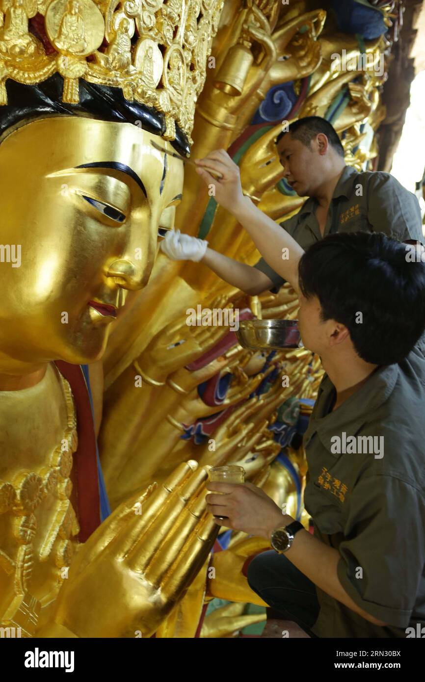 Workers restore a sculpture of Qianshou Guanyin (bodhisattva with a ...