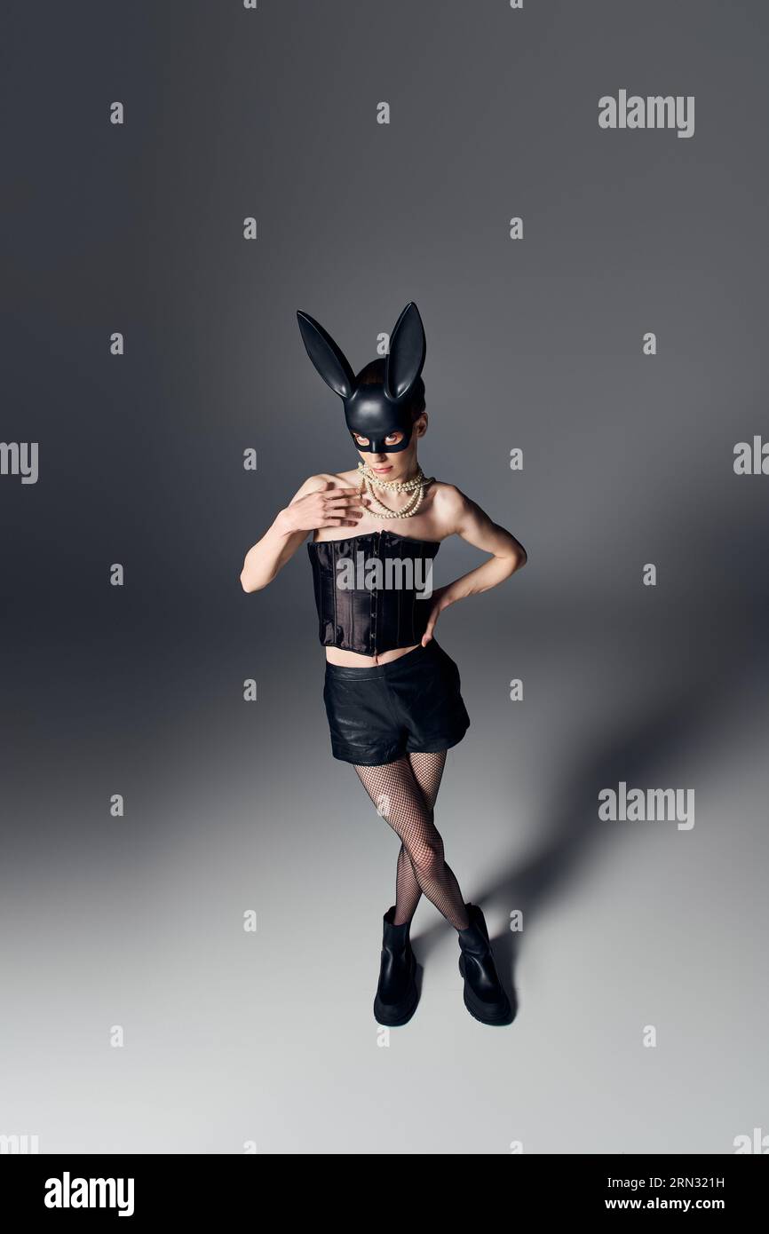 bold look, gender fluid person in corset posing in bdsm bunny mask on ...