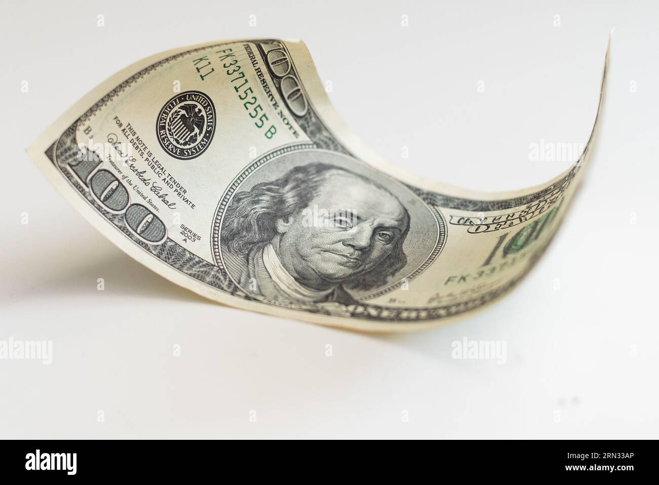Hundred dollar bill falling on white background Stock Photo - Alamy